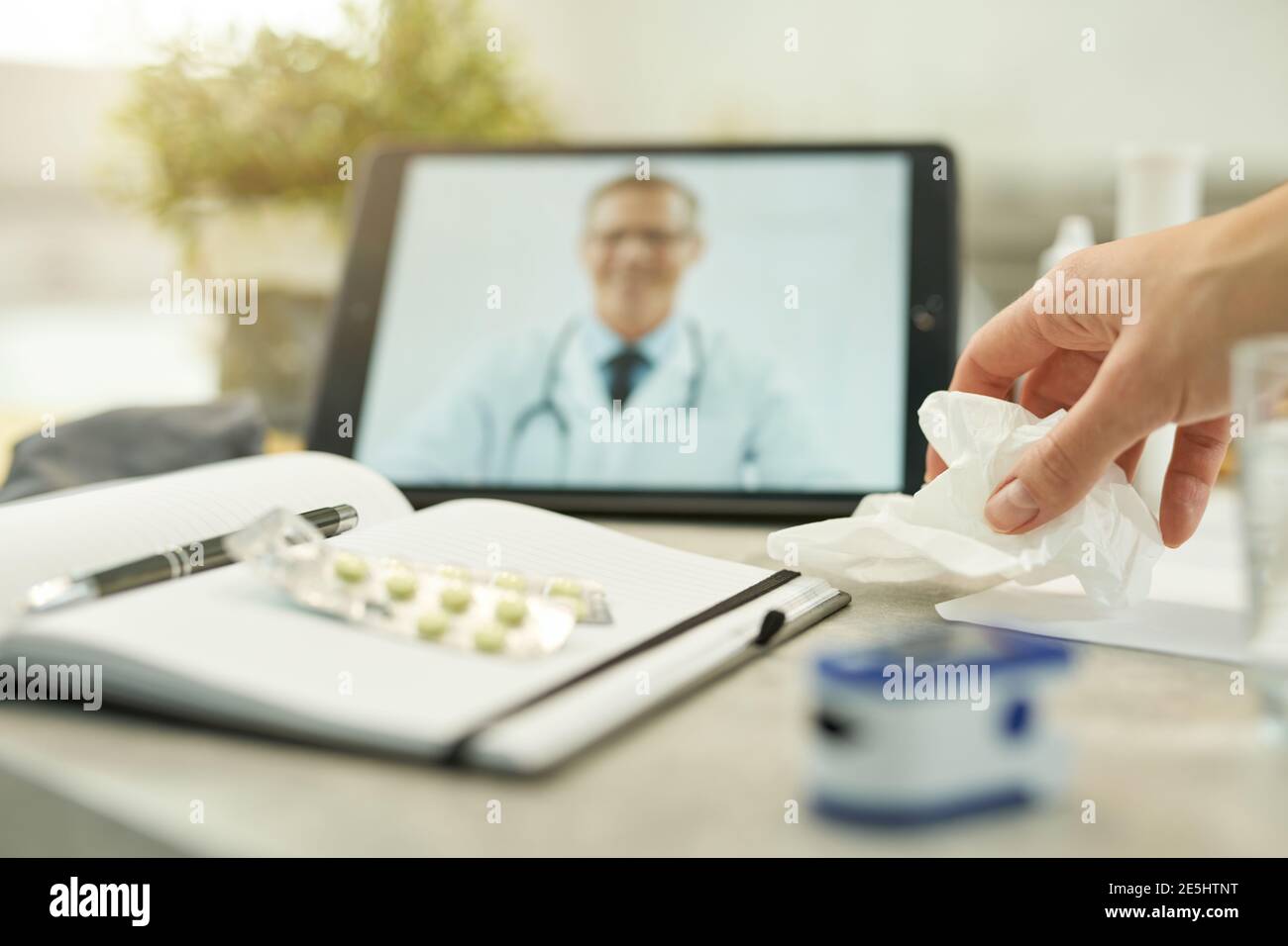 Selective focus of hand grabbing tissues from the table with medical ...