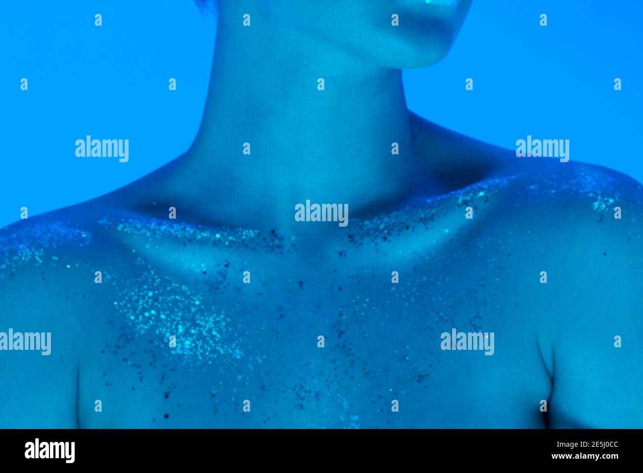 Close up female collarbones isolated on blue studio background in neon ...