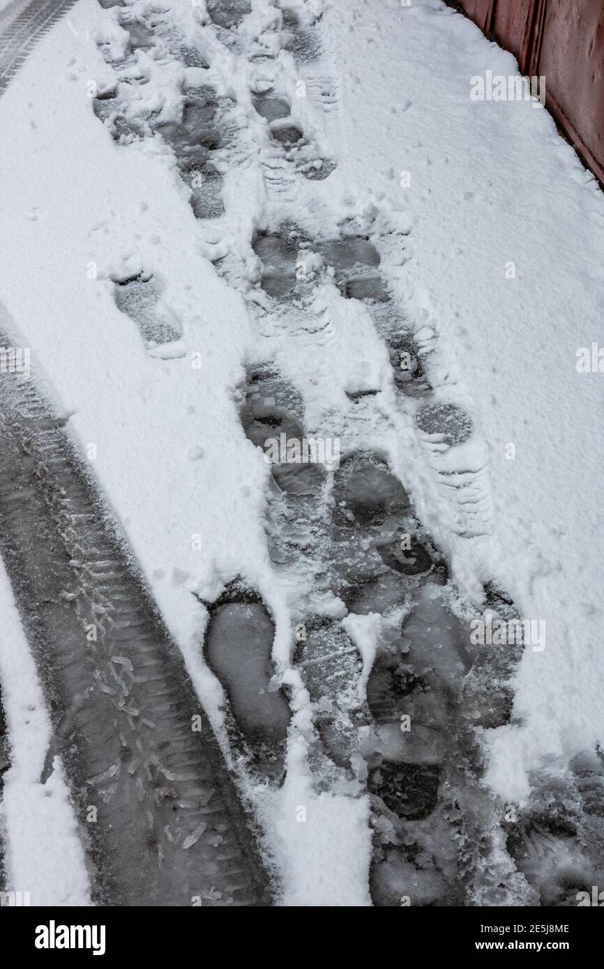 Tire tracks and footprints in snowy road hi-res stock photography and ...