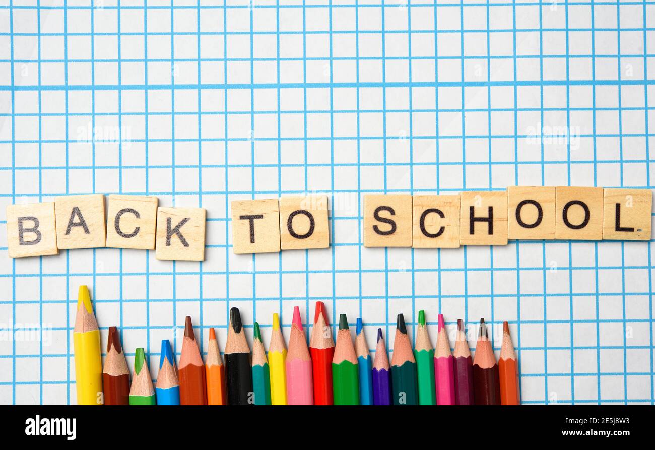 inscription from wooden letters back to school and multicolored pencils ...