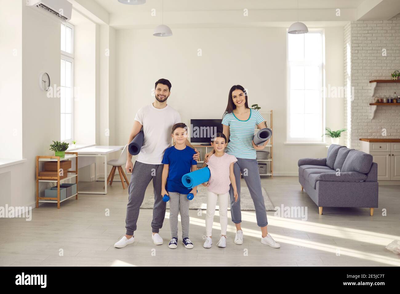 Portrait of happy smiling family with sports equipment after fitness ...