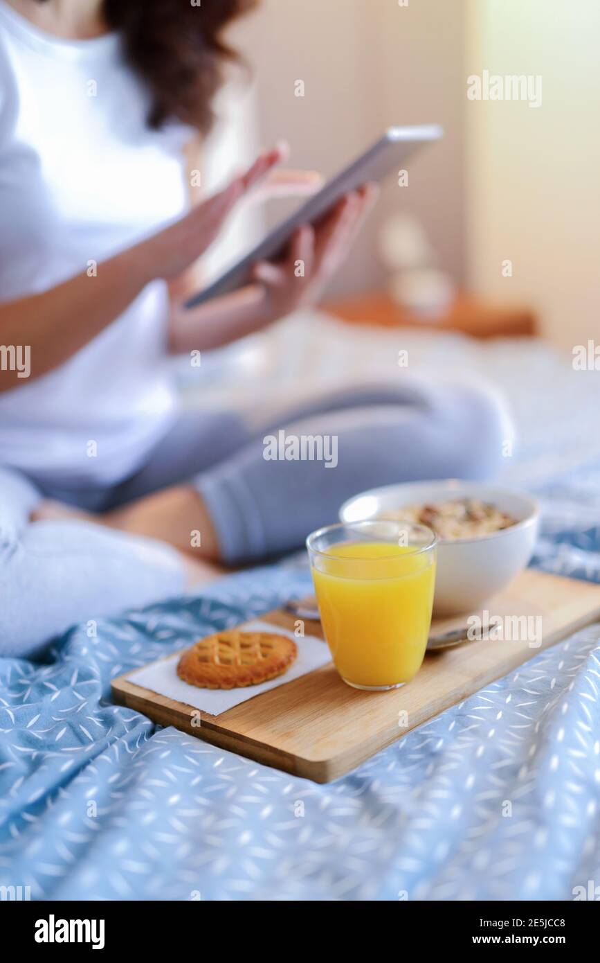 Healthy morning breakfast in a bed. Blurred figure of woman holding ...