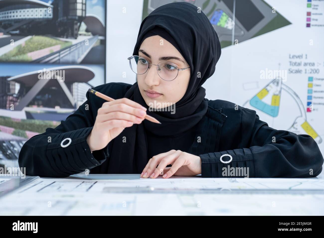 Female arab architect looking at her pencil Stock Photo - Alamy