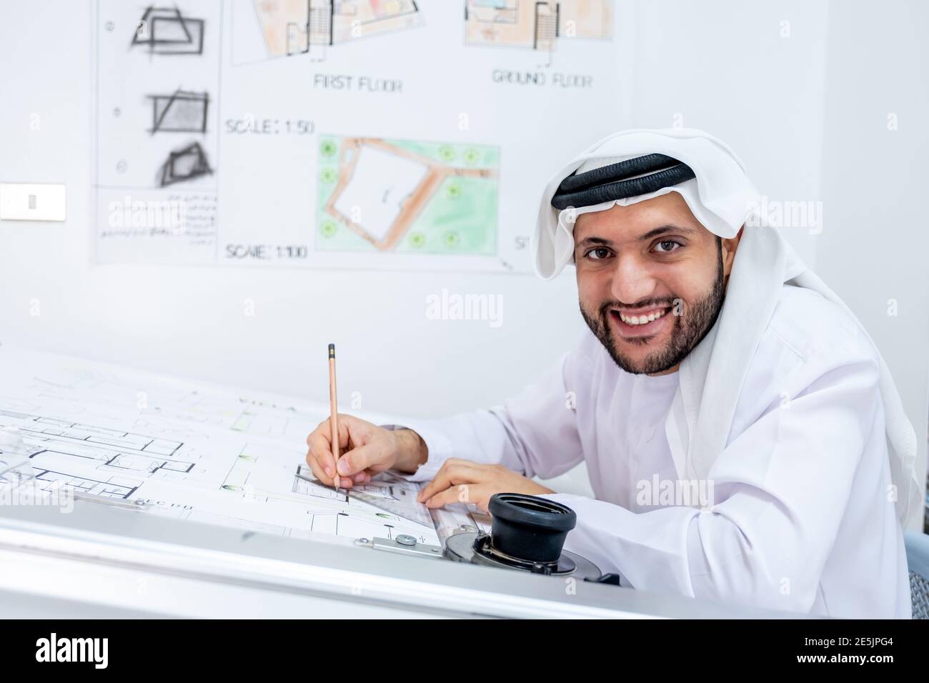 Arabic architecture working on his project and smiling Stock Photo - Alamy