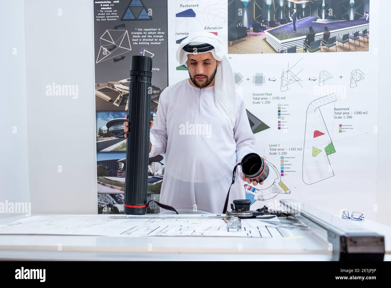 Male arab architect standing and opening his bag to show his project ...