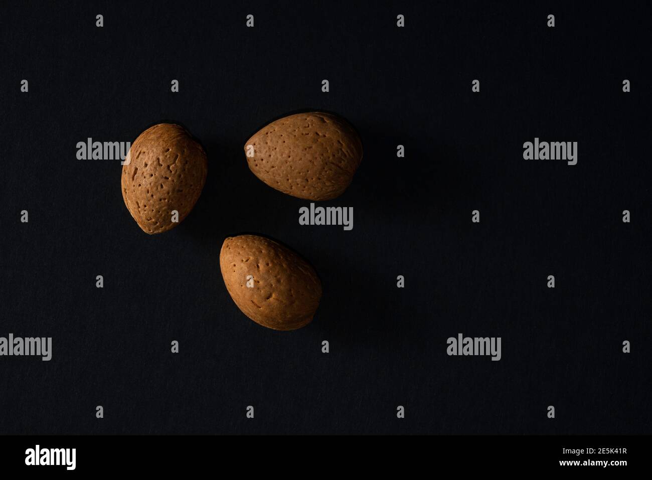 Almonds in nutshell isolated over black background Stock Photo - Alamy