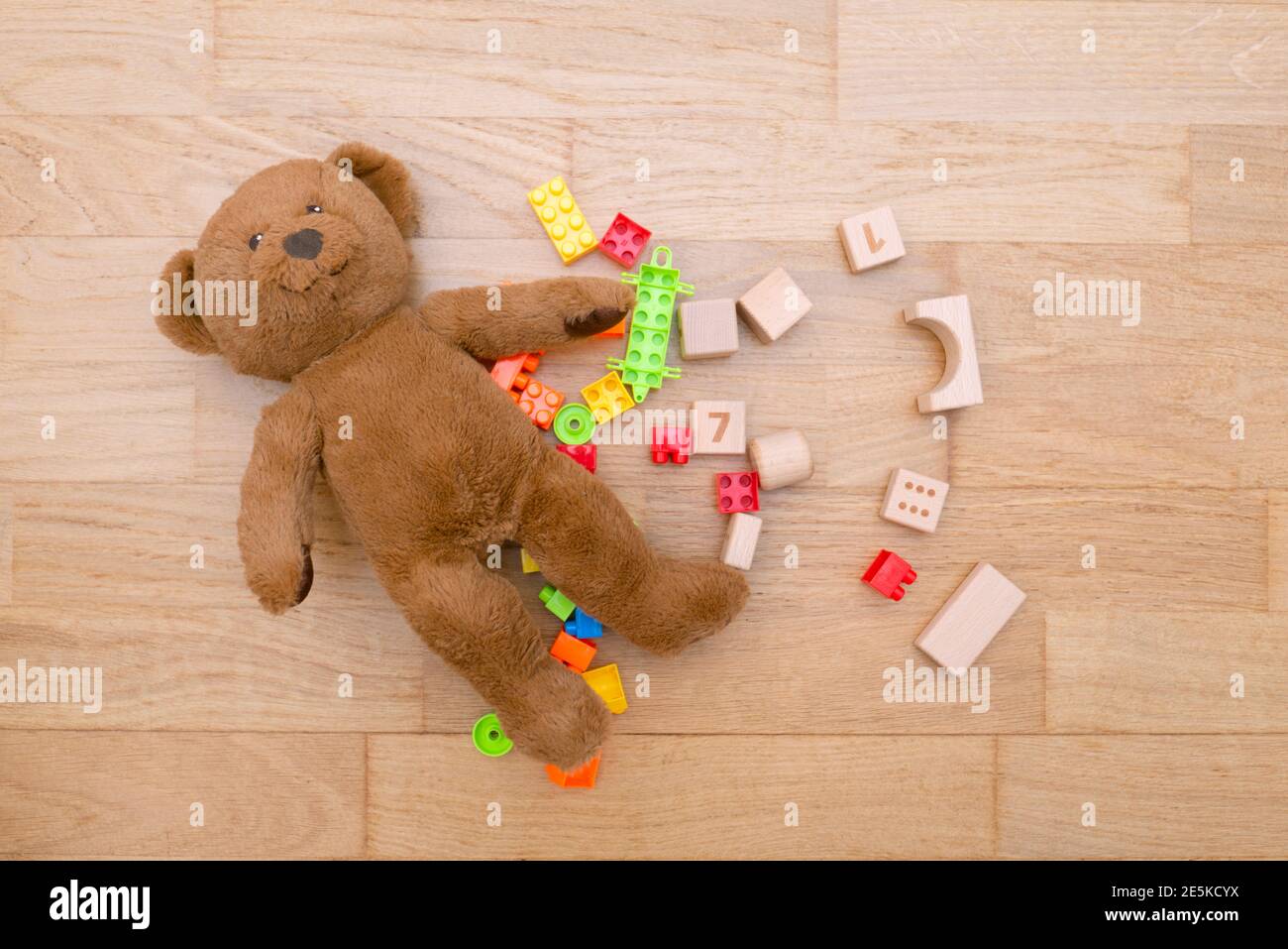 Scattered on wooden floor children's toys, plastic blocks, construction ...