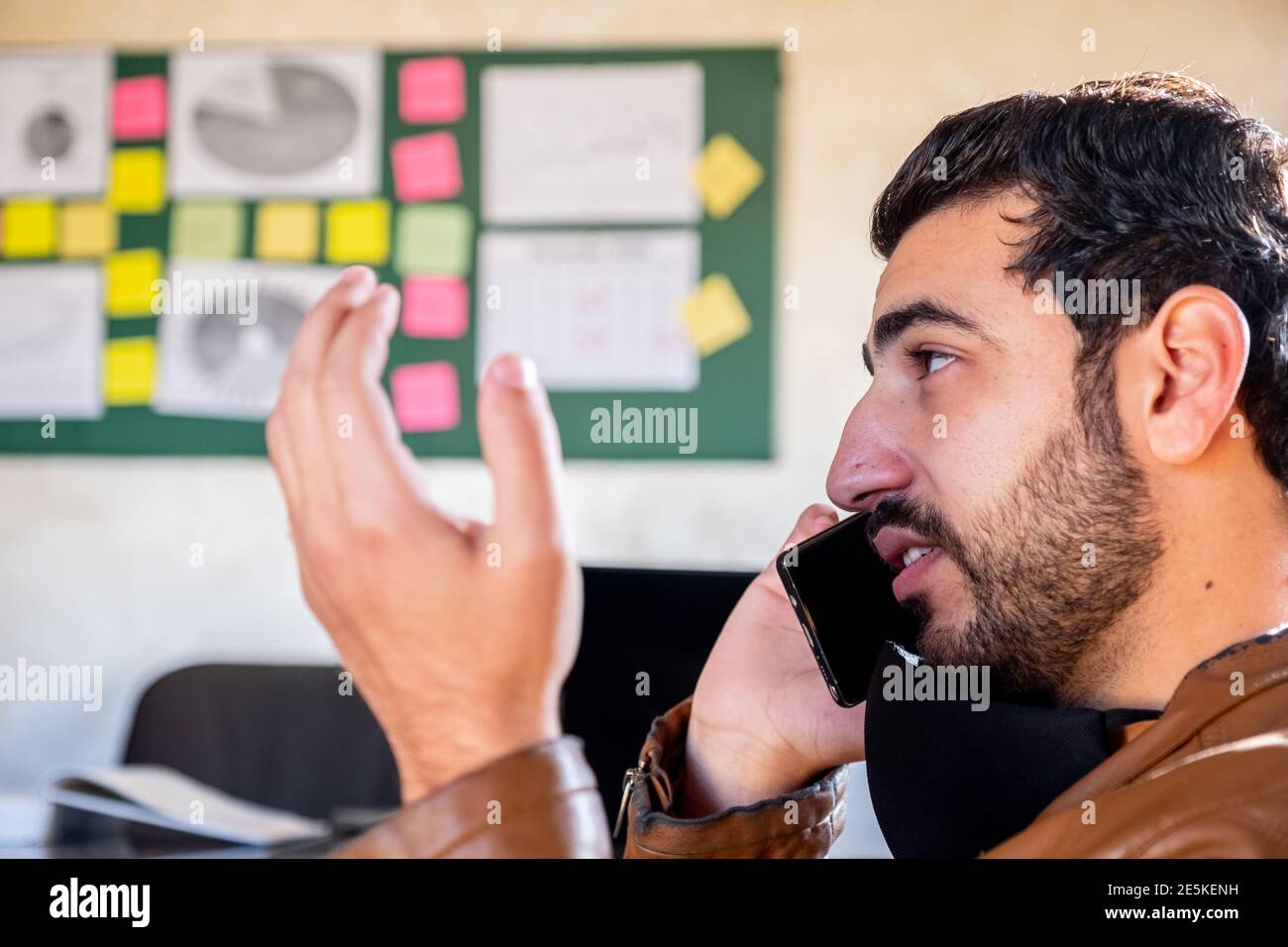 man using his contacting through his phone while waiting the assistance ...