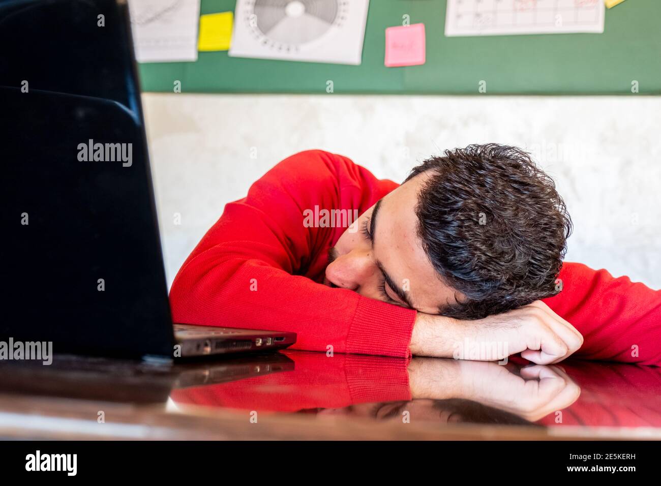 young man is sleeping in his work taking a small nap in front of this ...