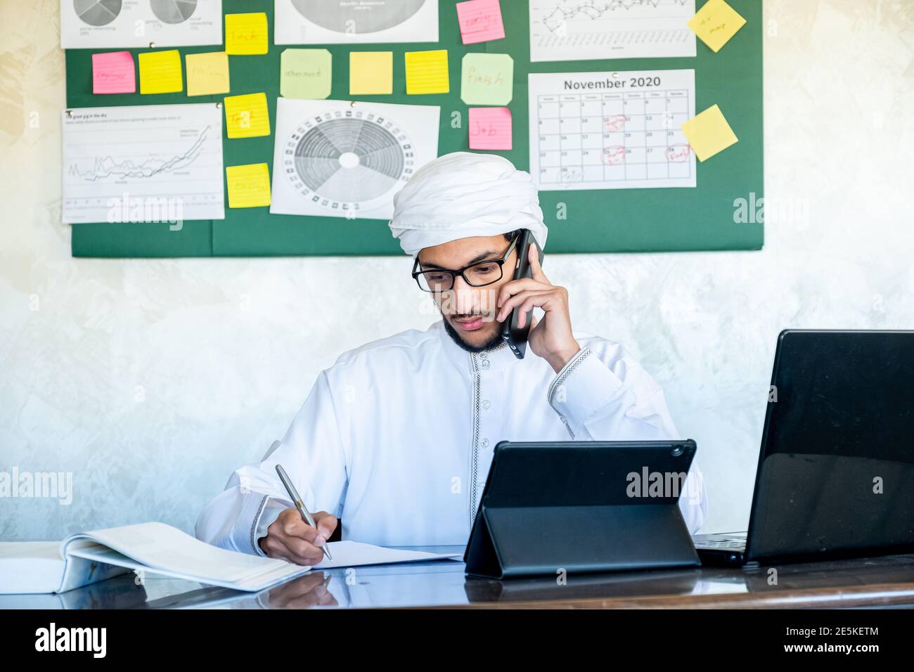arabian man using his mobile phone while working for communication ...