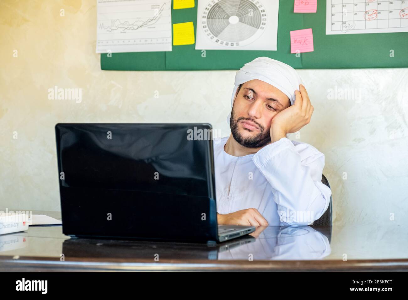 young man is feeling boared in his work taking a small nap in front of ...