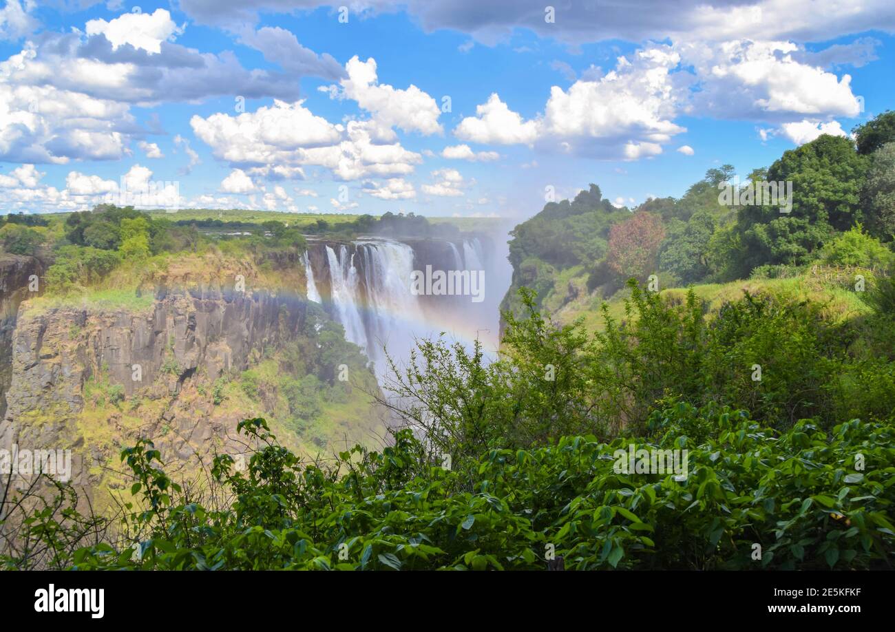 The iconic Mosi-Oa-Tunya waterfall aka Victoria Falls, with a rainbow ...