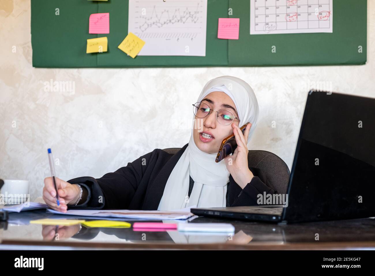 Muslim women working in the office from home using laptop and mobile ...