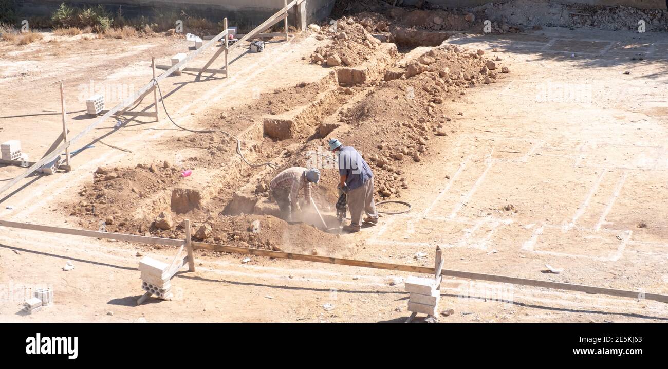 Workers are digging up the foundations for a new house according to the ...