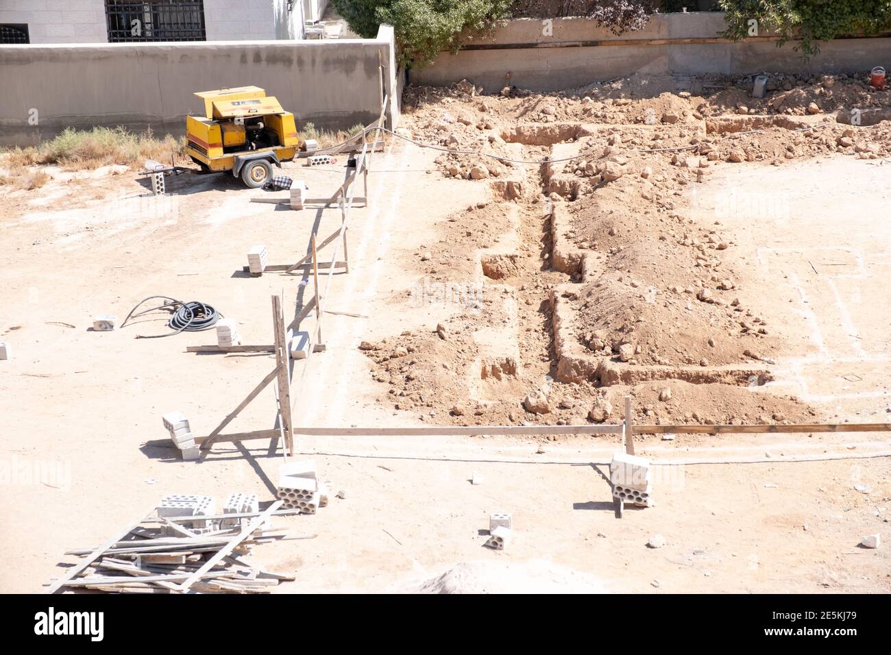 Workers are digging up the foundations for a new house according to the ...