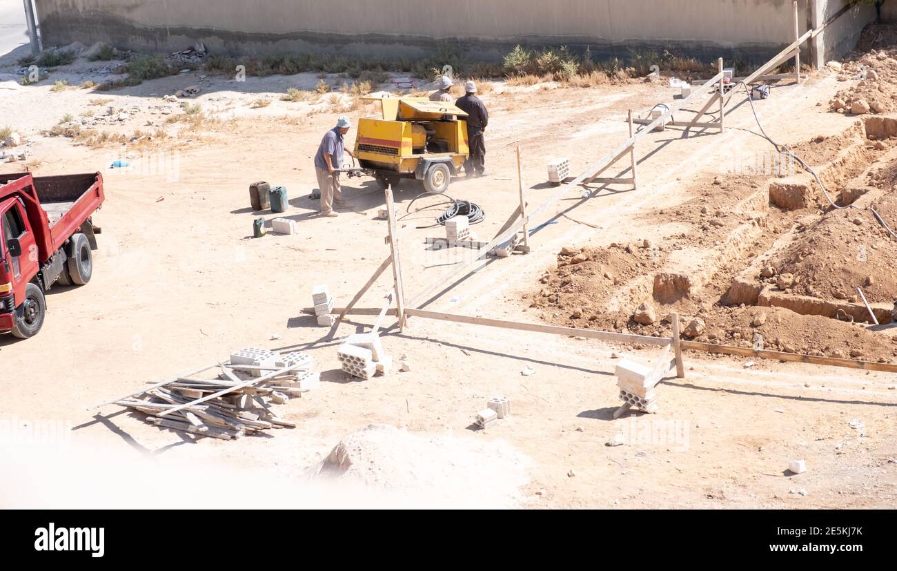 Workers are digging up the foundations for a new house according to the ...