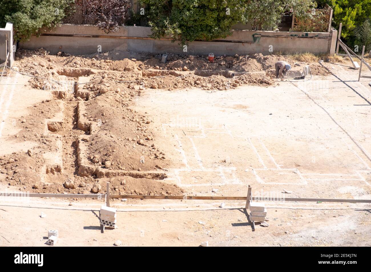 Workers are digging up the foundations for a new house according to the ...