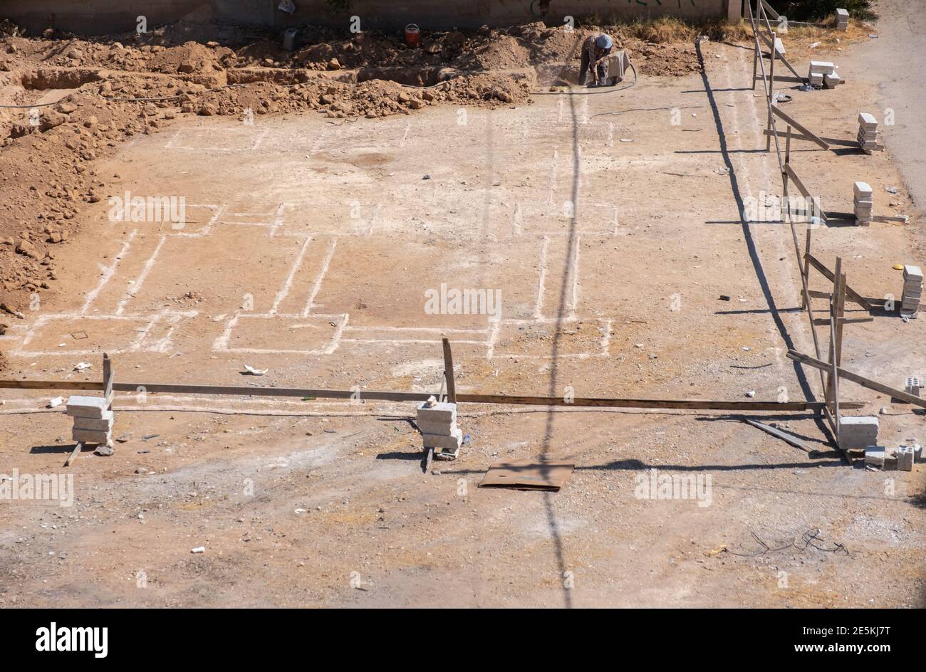 Workers are digging up the foundations for a new house according to the ...