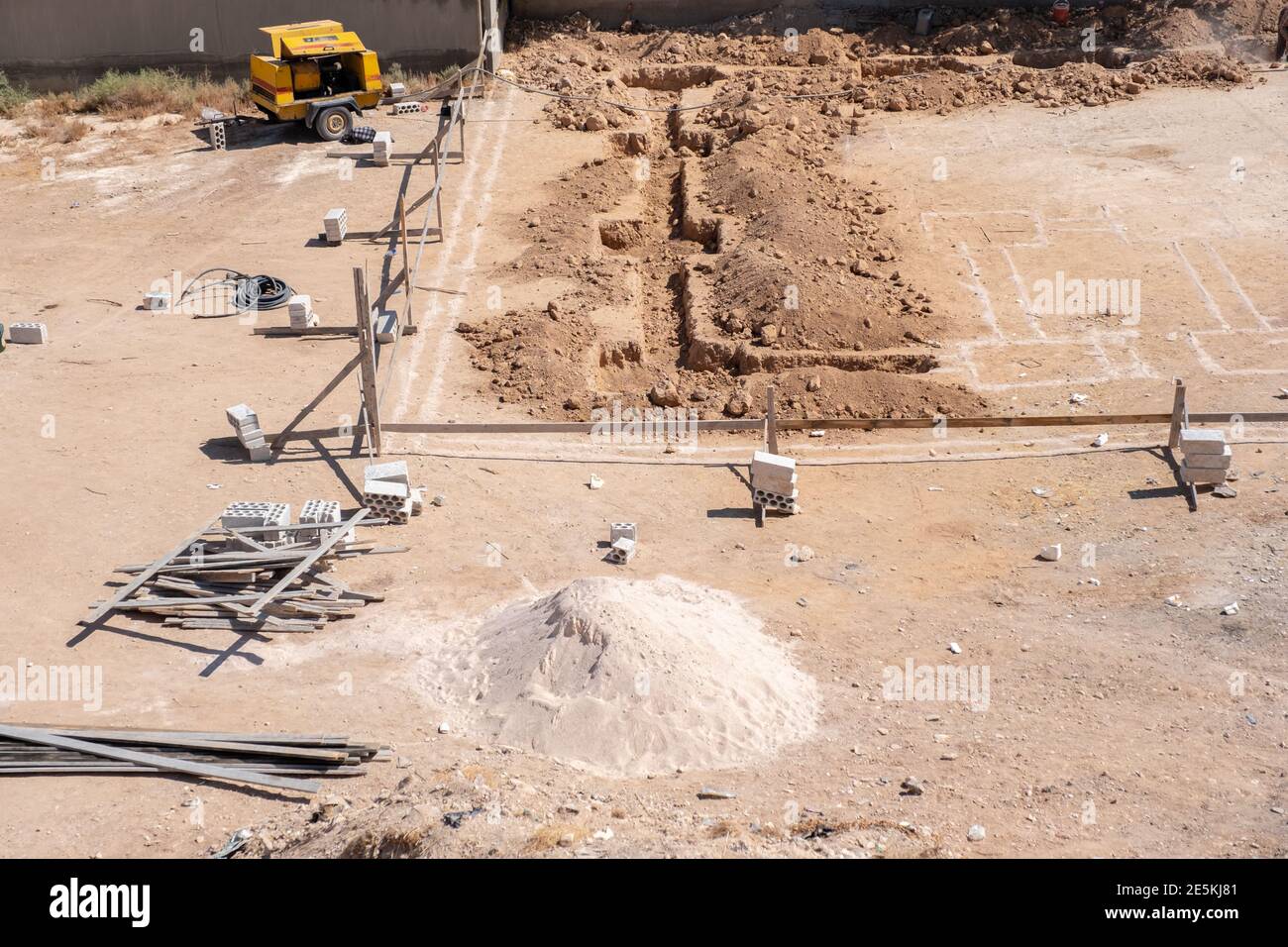 Workers are digging up the foundations for a new house according to the ...