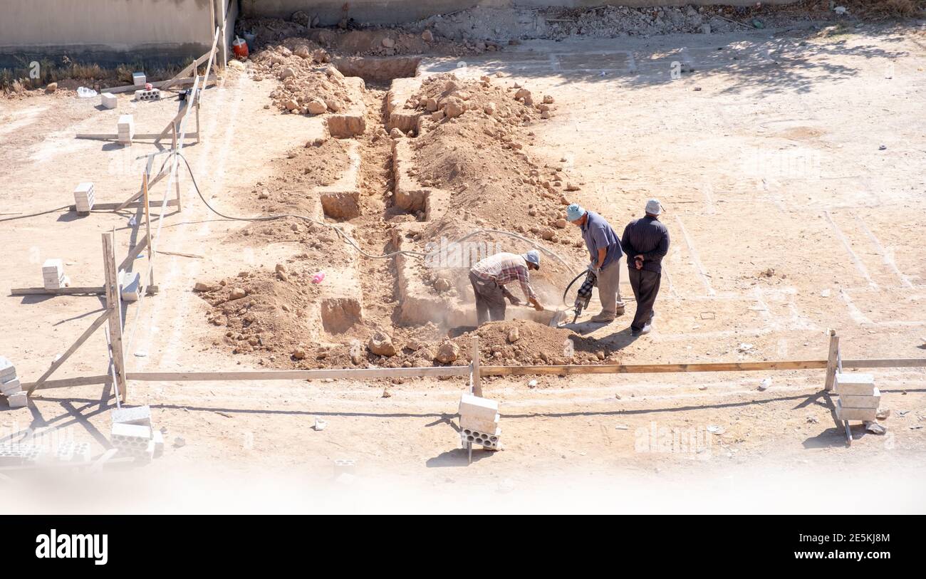 Workers are digging up the foundations for a new house according to the ...