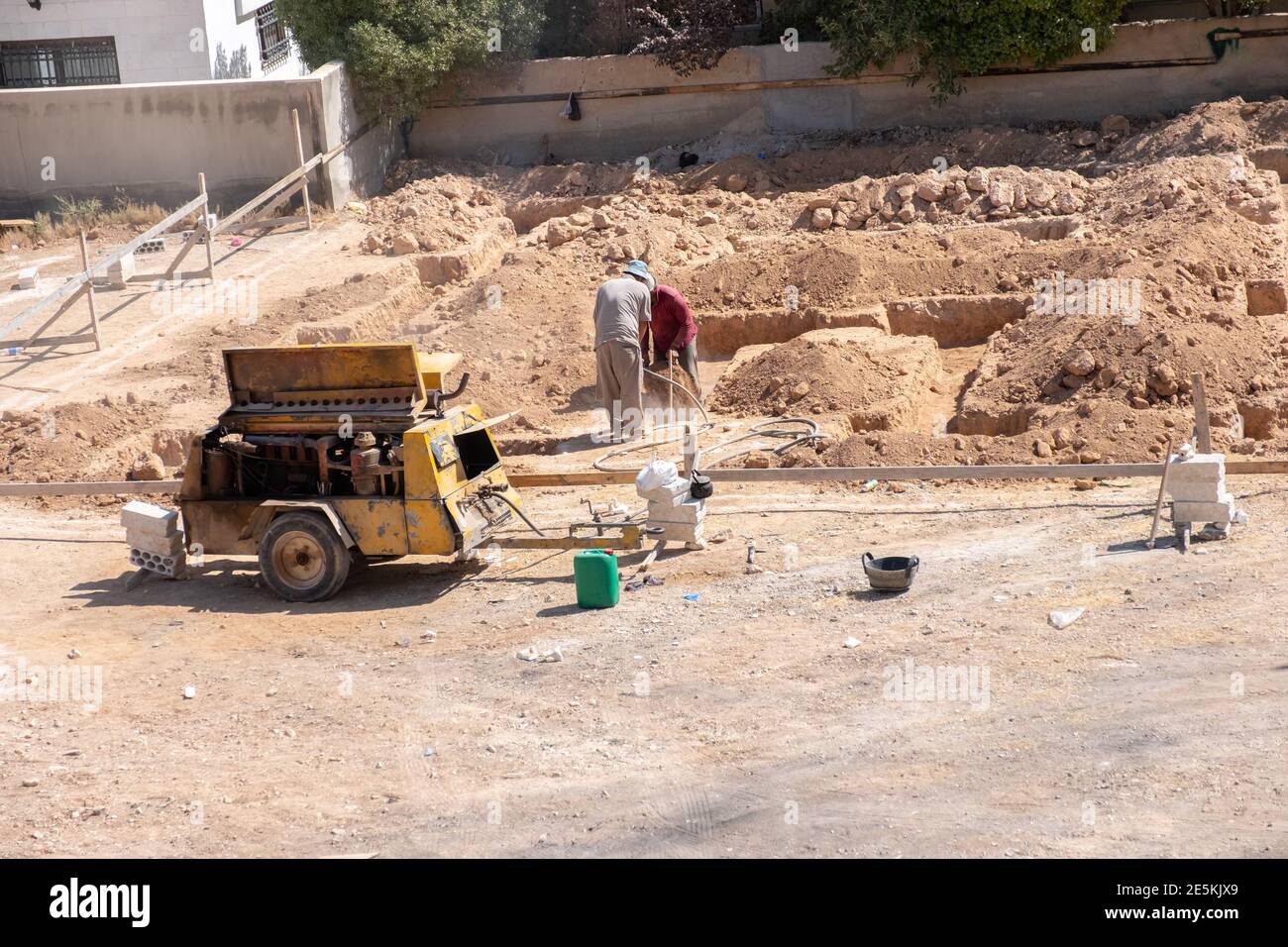 Workers are digging up the foundations for a new house according to the ...