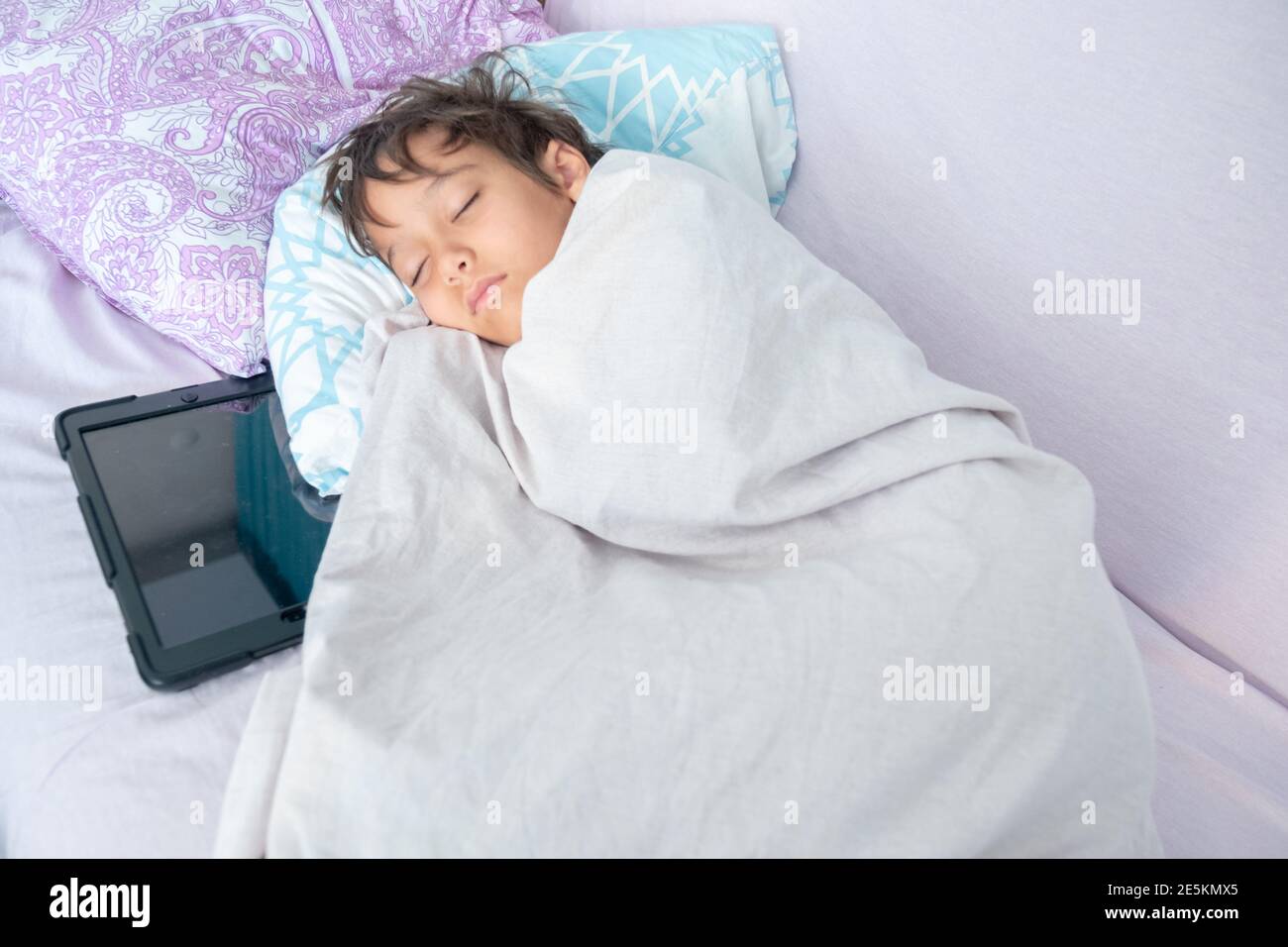 Cute boy sleeping on a white sofa with beautiful calm look on his face ...