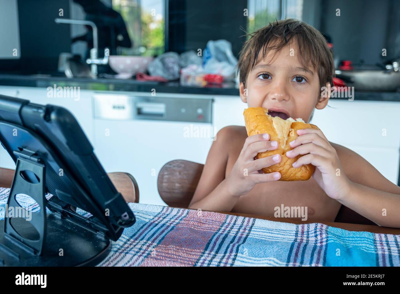 Boy is eating sandwitch and watching a movie Stock Photo - Alamy