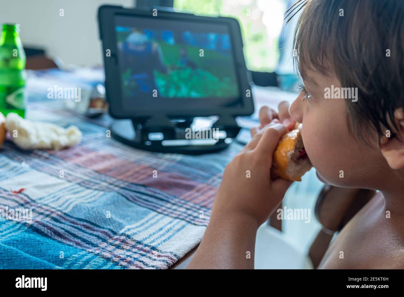Boy is eating sandwitch and watching a movie Stock Photo - Alamy