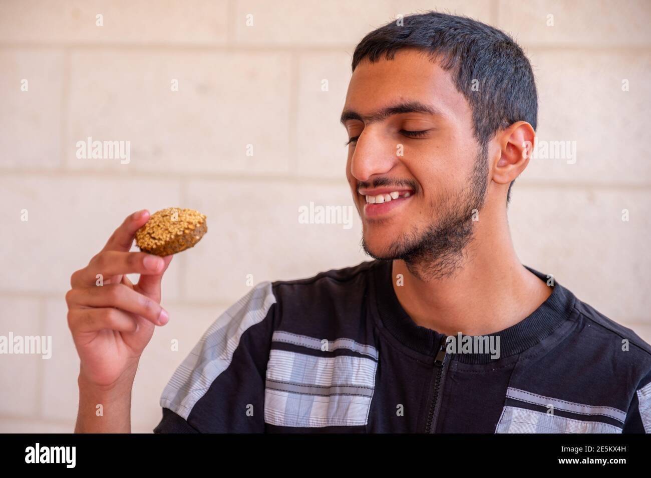Muslim man is eating falafel and enjoying his time Stock Photo - Alamy