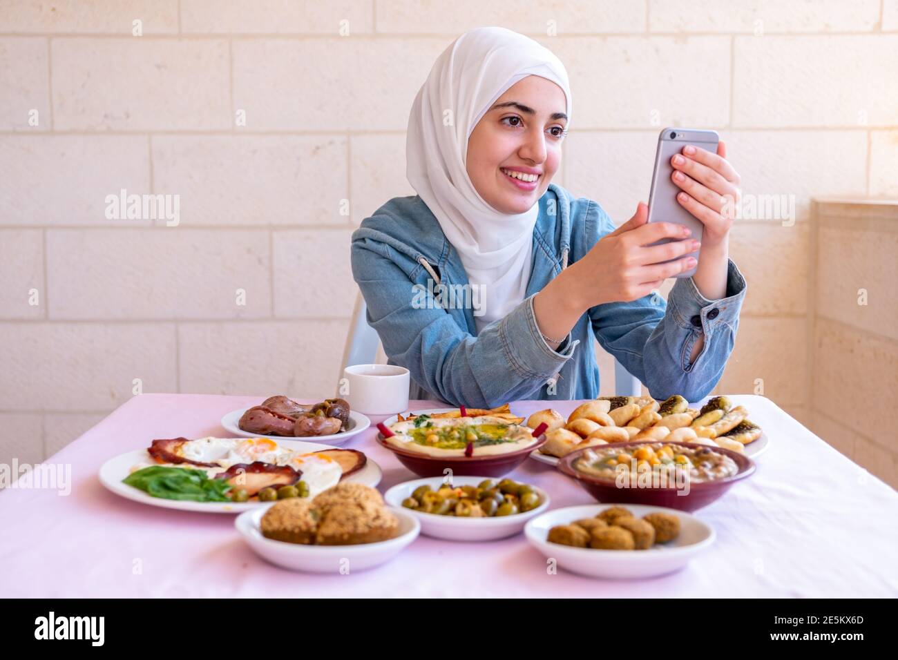 Muslim girl are eating breakfast and calling her friends Stock Photo ...