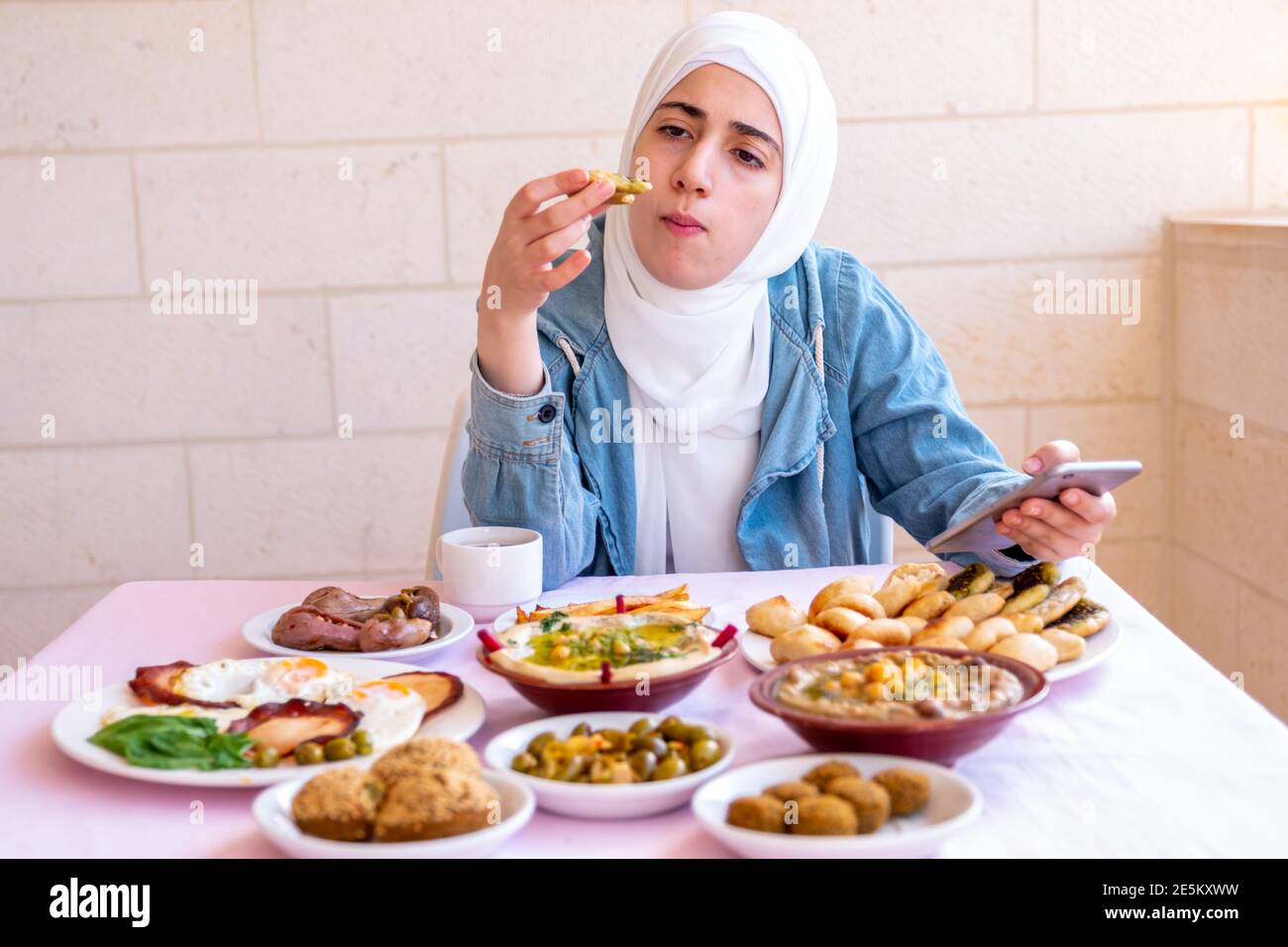 Muslim girl is eating her breakfast Stock Photo - Alamy