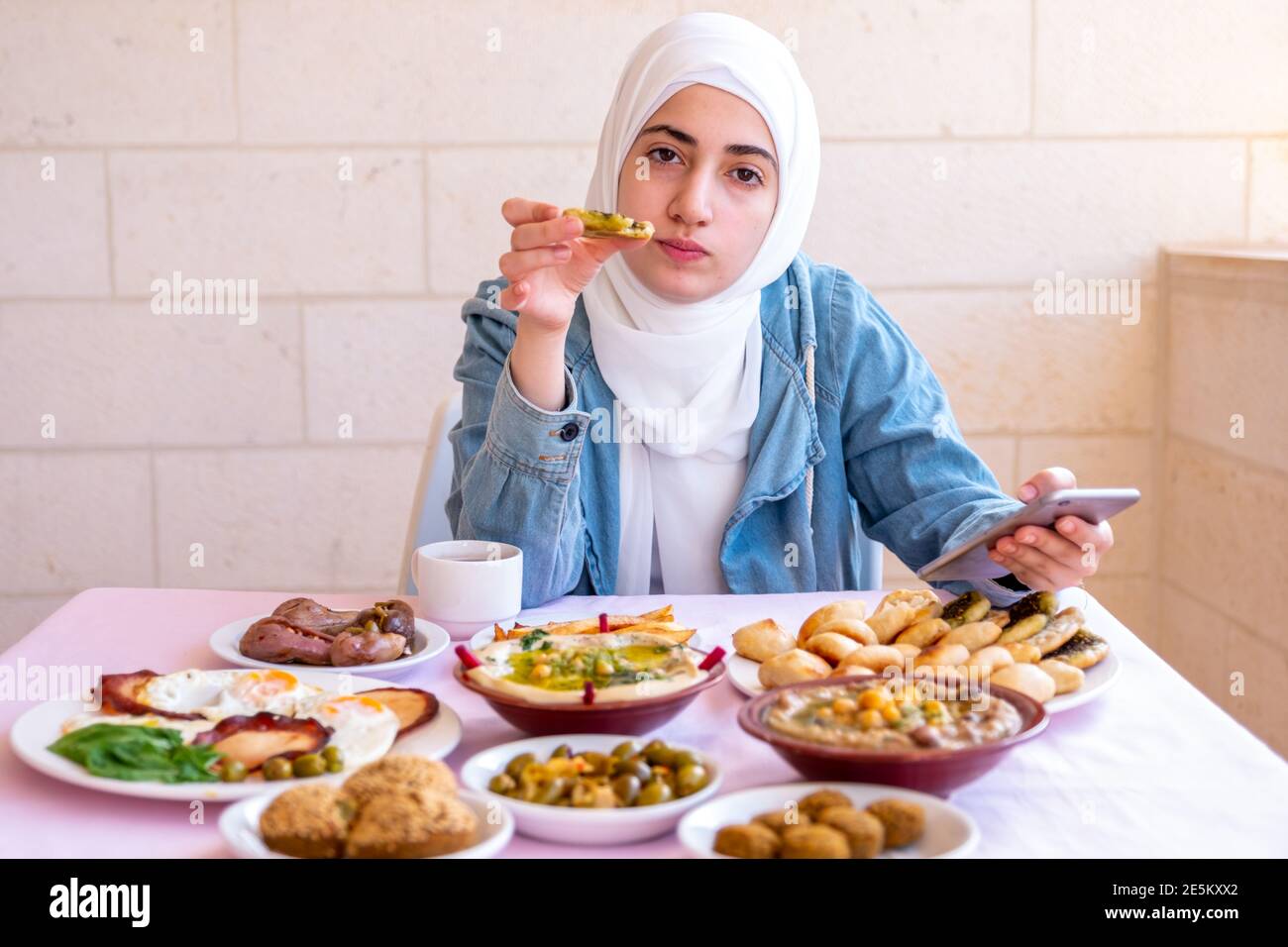 Muslim girl is eating her breakfast Stock Photo - Alamy
