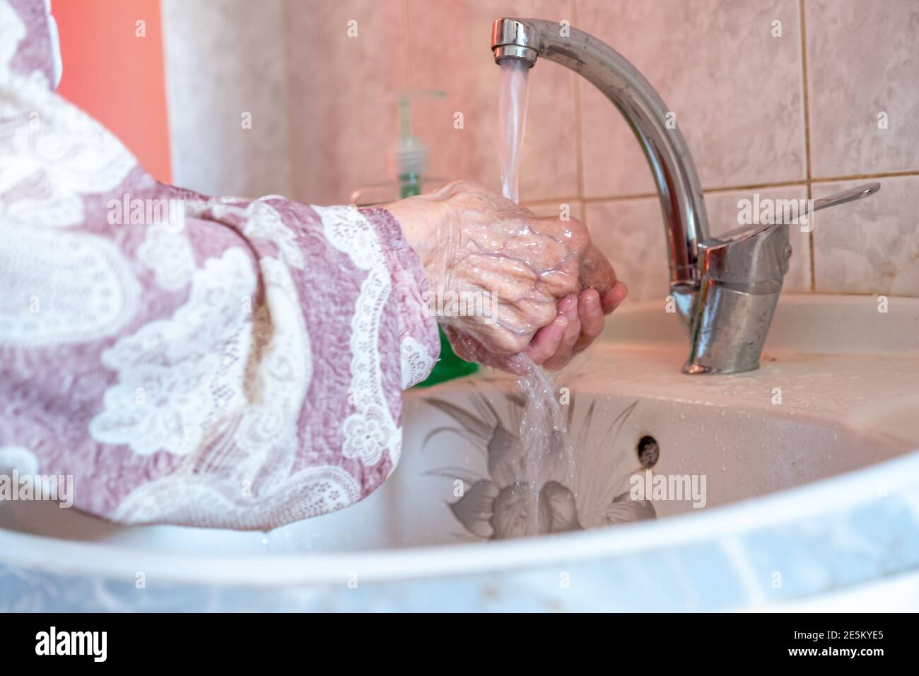 Old woman is washing her hands Stock Photo - Alamy