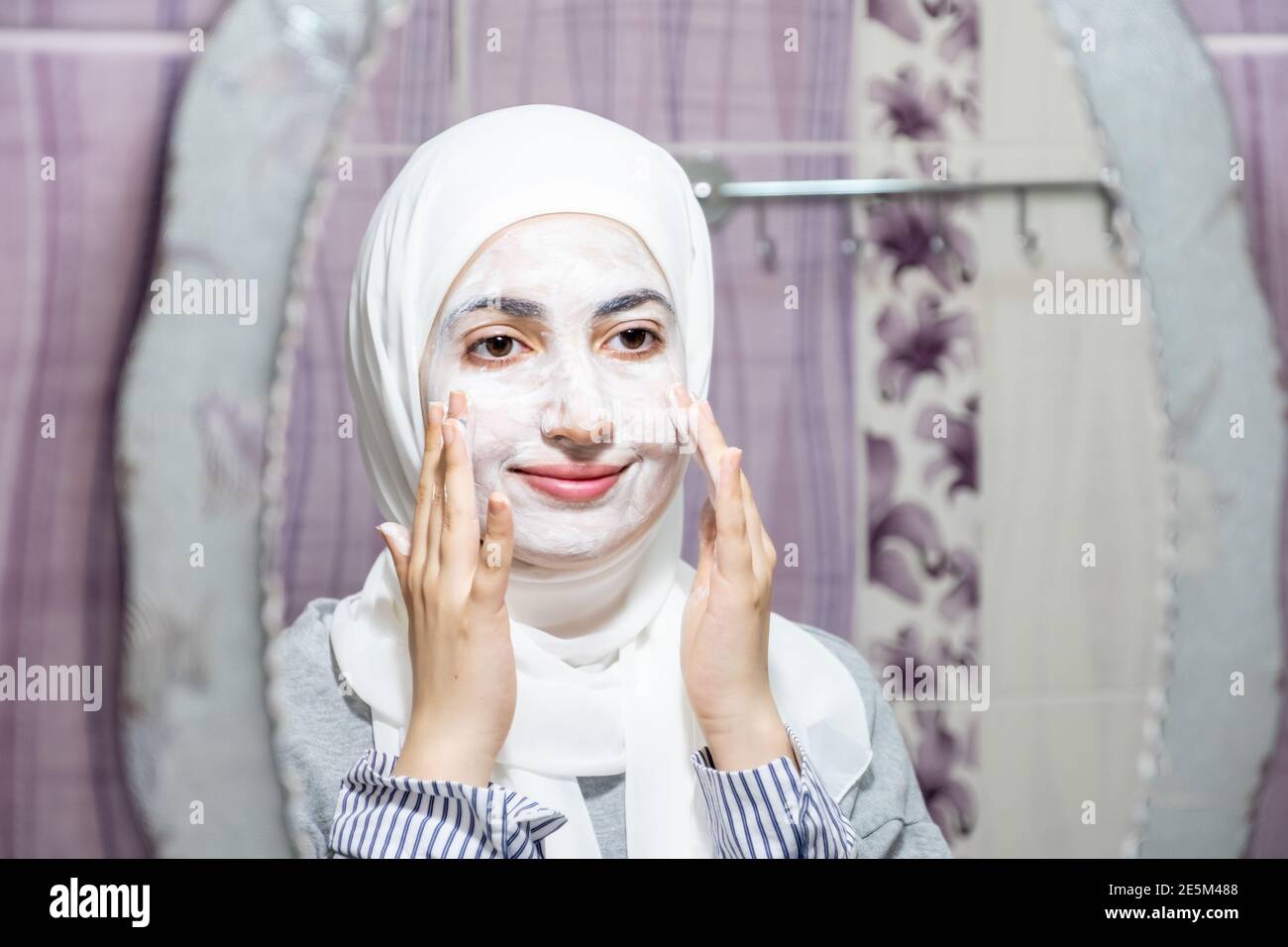 Muslim woman applying facial mask Stock Photo - Alamy