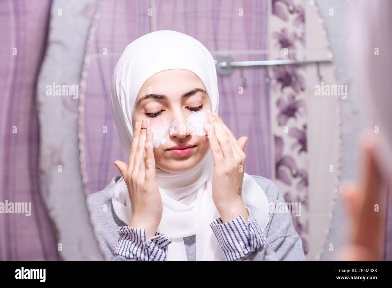 Muslim woman applying facial mask Stock Photo - Alamy