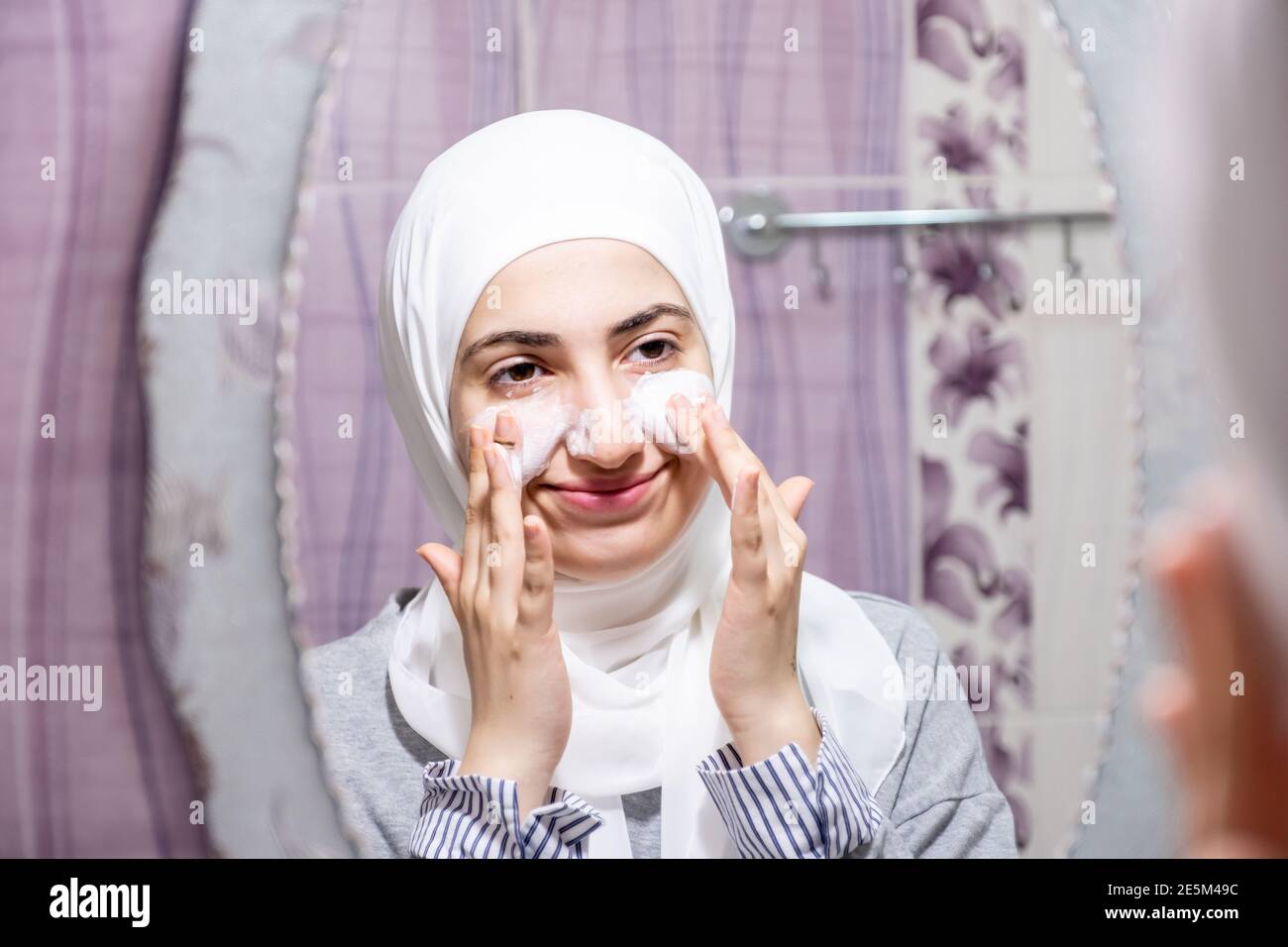 Muslim woman applying facial mask Stock Photo - Alamy