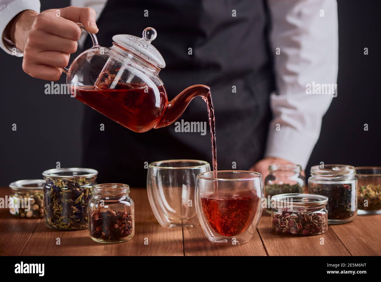 Tea master pouring red tea into glass cups Stock Photo - Alamy