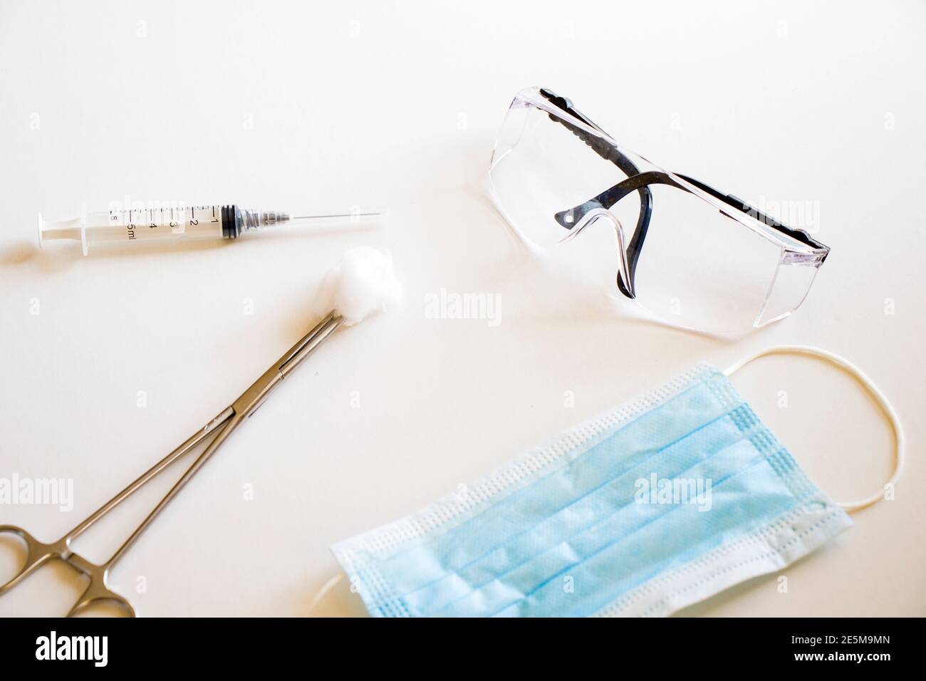 Needle, face masks and safety glasses on the white background, sterile ...