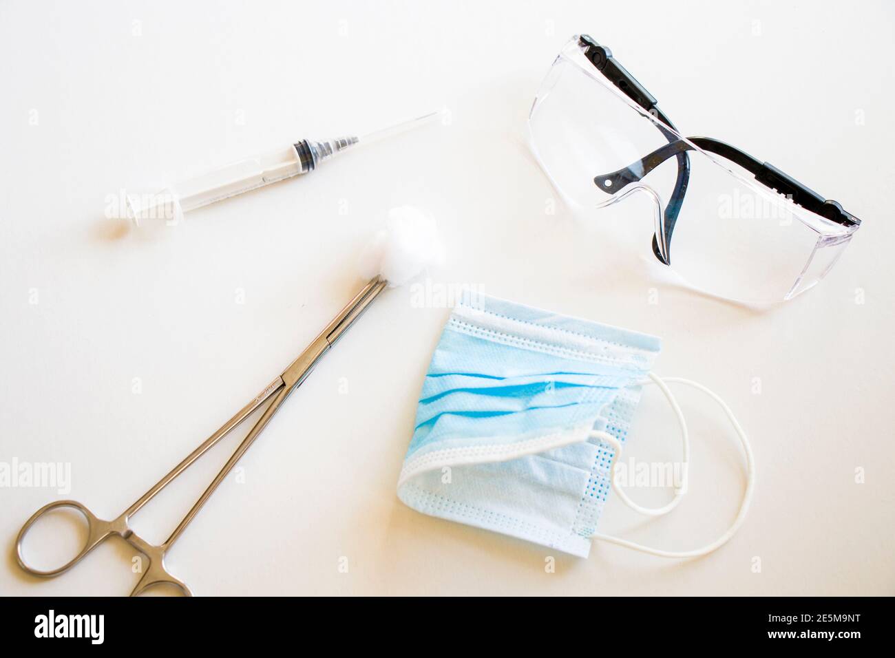 Needle, face masks and safety glasses on the white background, sterile ...