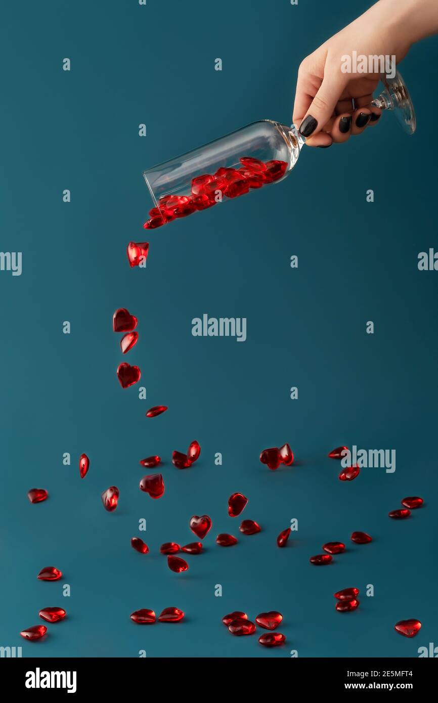 Beautiful card with female hand pouring red hearts from champagne glass ...