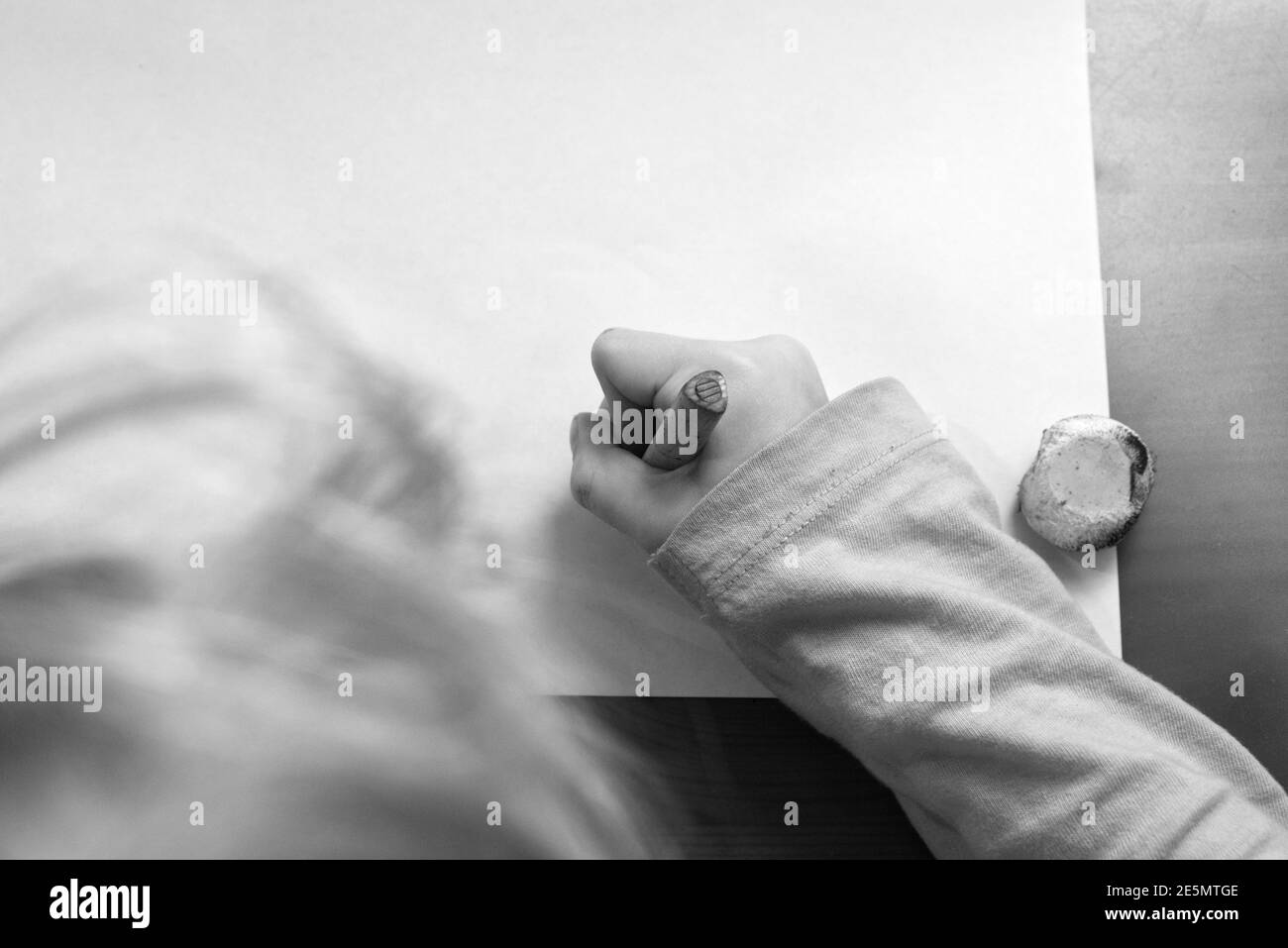 Child writing or drawing with pencil, view from above, shallow depth of ...