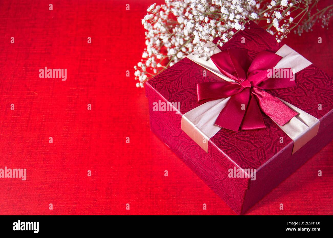 Red color gift box with flowers on red background Stock Photo - Alamy