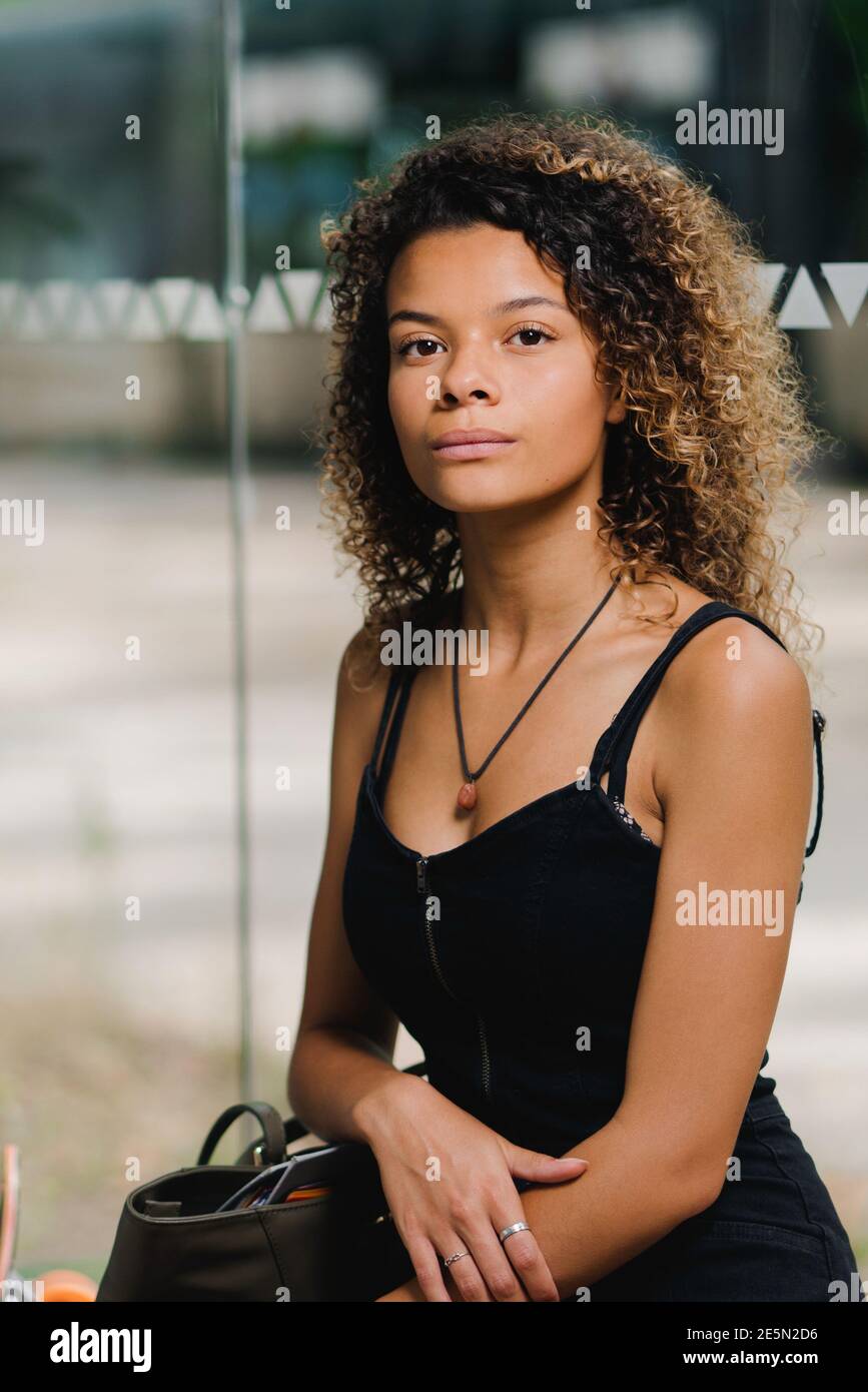 Beautiful young woman waiting at bus station in the city Stock Photo ...