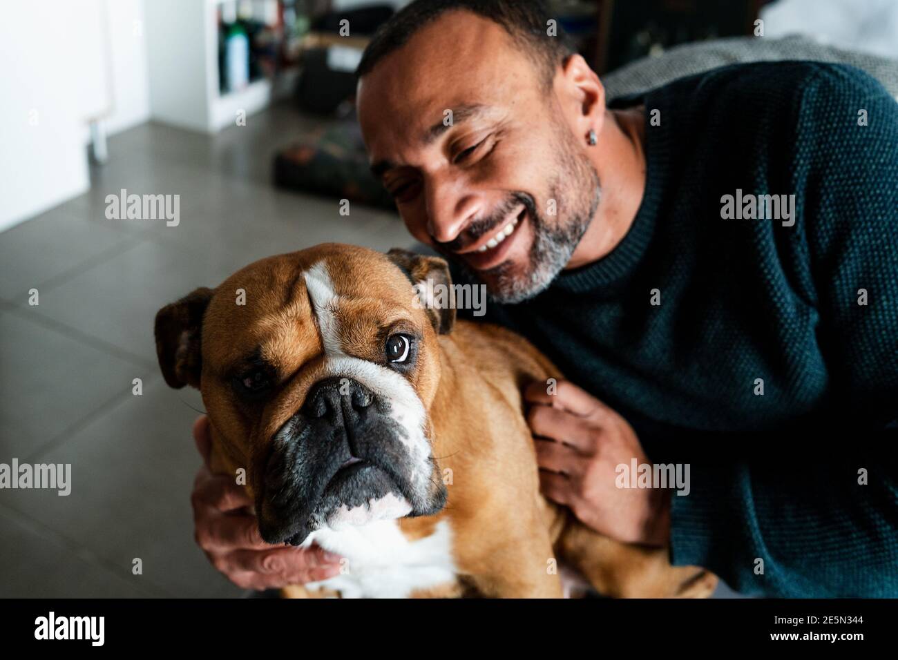dog owner cuddling his bulldog on the sofa Stock Photo - Alamy