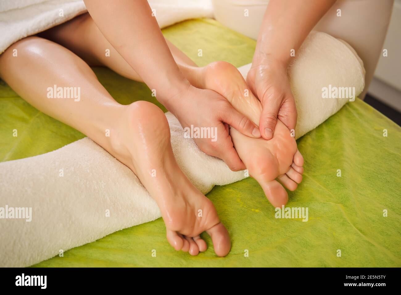 Traditional foot massage. Beautiful woman enjoying a treatment in a spa ...