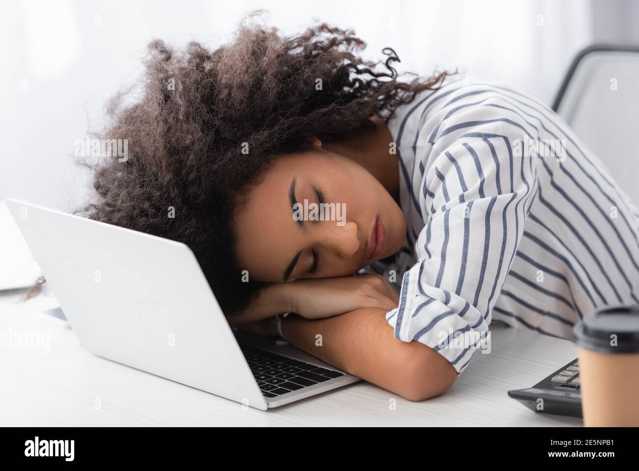 exhausted african american woman sleeping on laptop at home Stock Photo ...