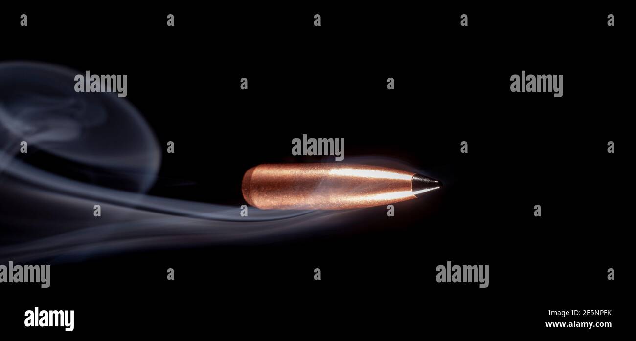 Polymer tipped bullet racing across a black background with smoke ...