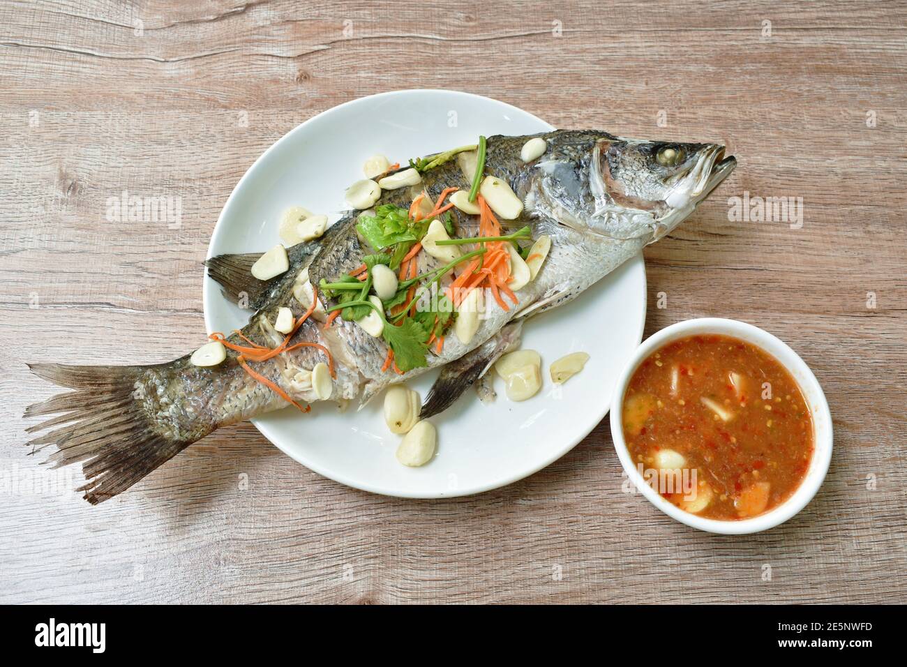 steamed bass fish with garlic dipping spicy sauce on table Stock Photo ...