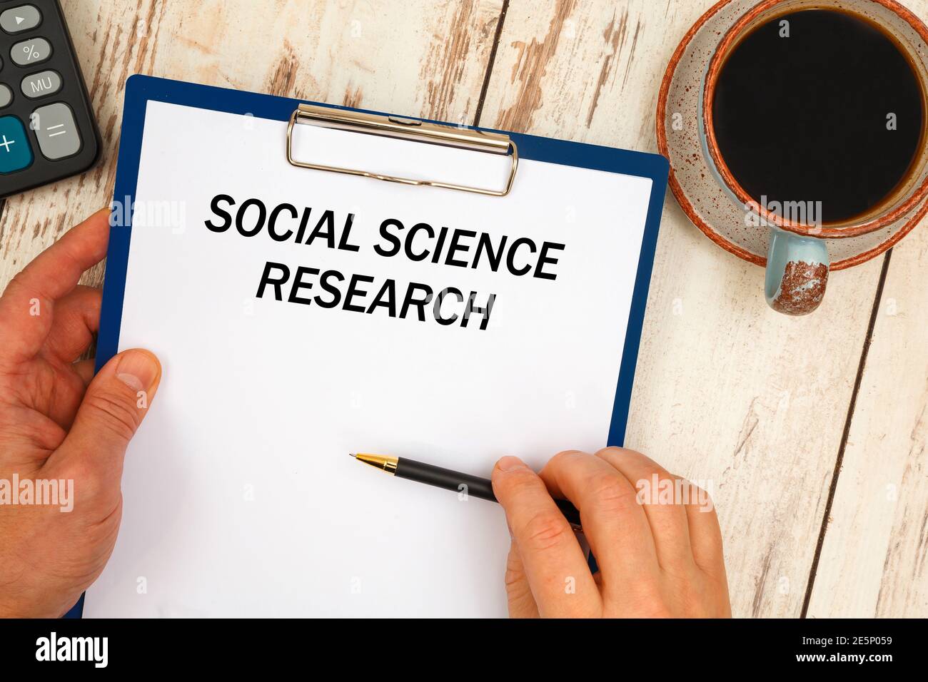 Paper with text Social Science Research on the office table, calculator ...