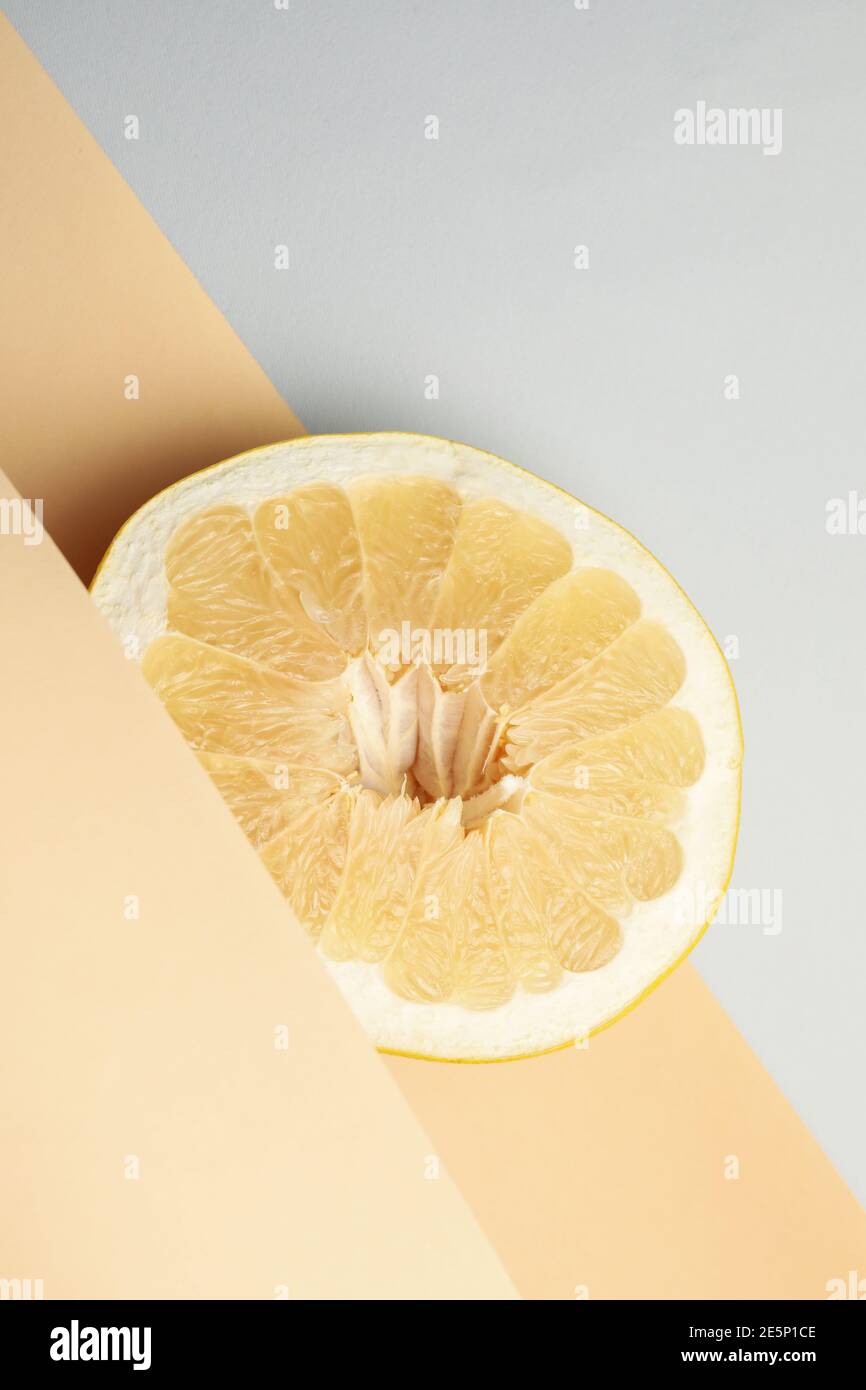 Slice of ripe pomelo fruit on three tone background Stock Photo - Alamy